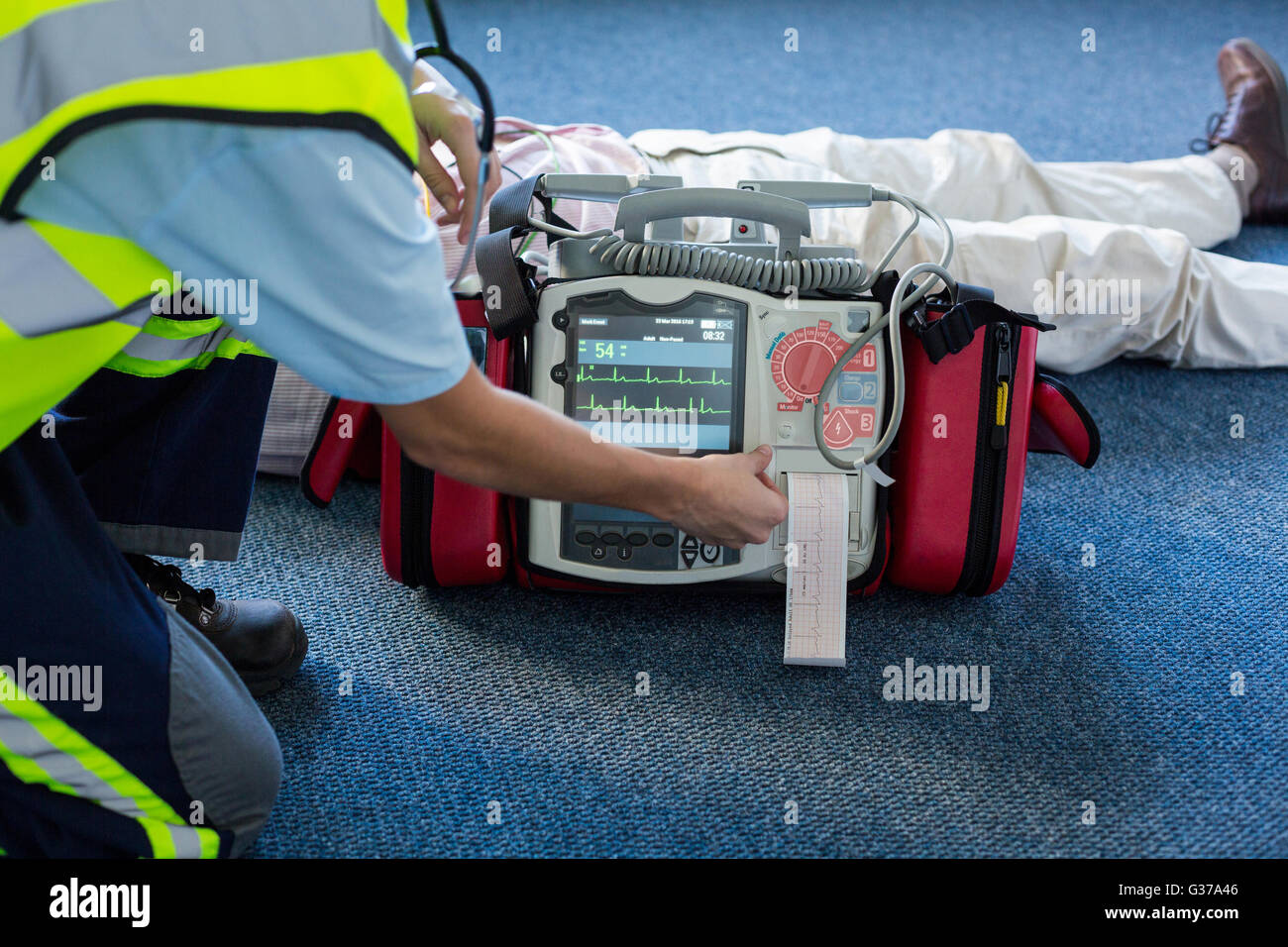 Paramedic using an external defibrillator during cardiopulmonary ...