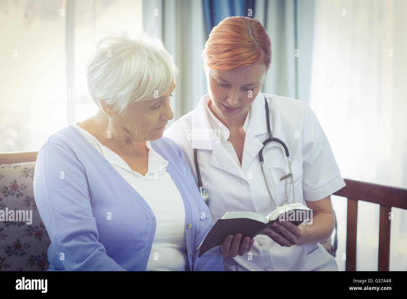 Doctor and patient reading a book Stock Photo - Alamy