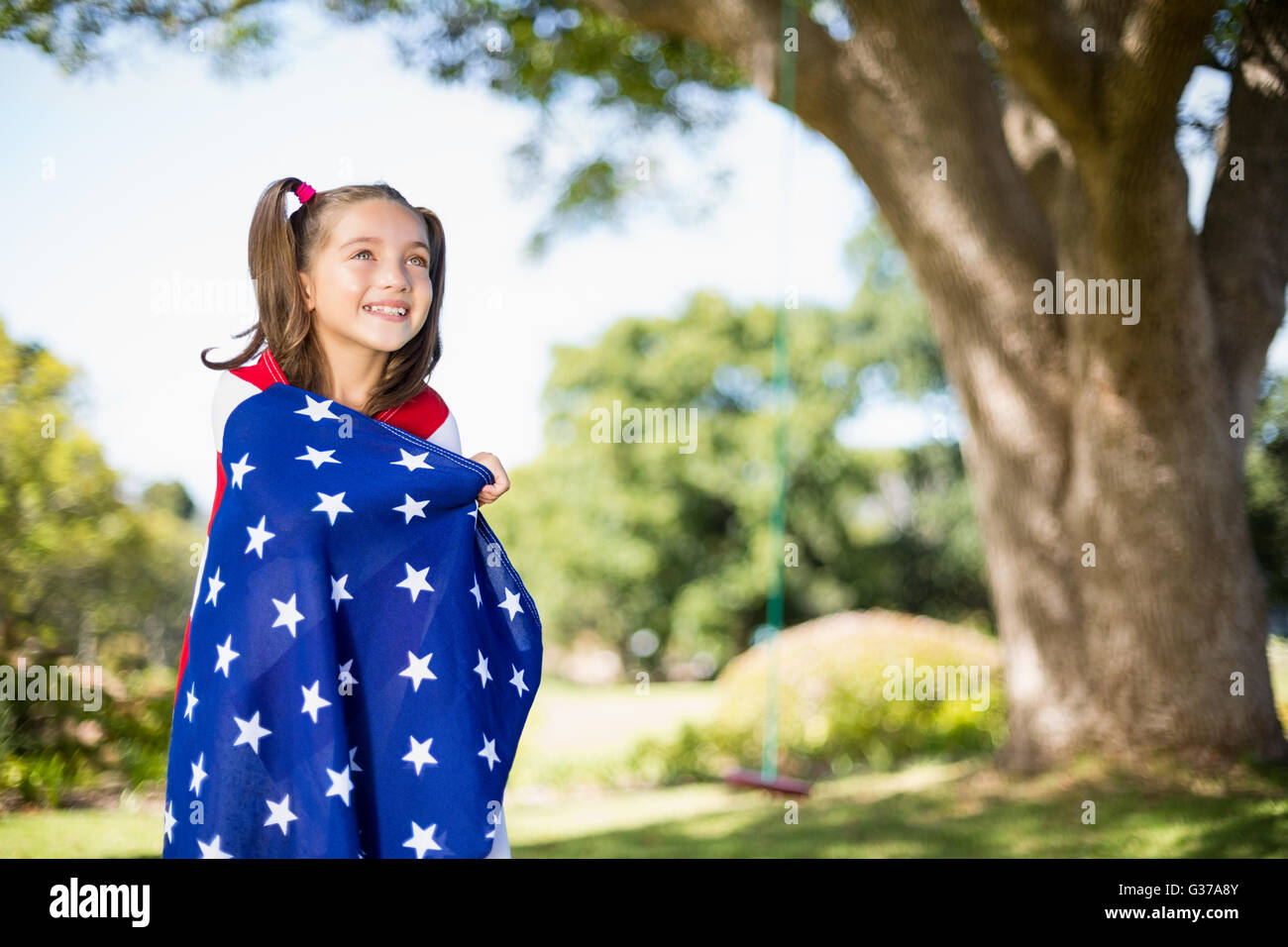 Young girl wrapped in American flag Stock Photo - Alamy