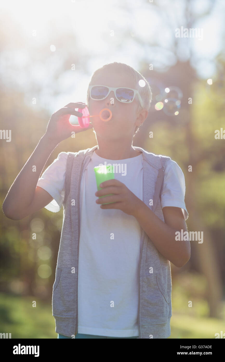 Young boy blowing bubbles through bubble wand Stock Photo - Alamy
