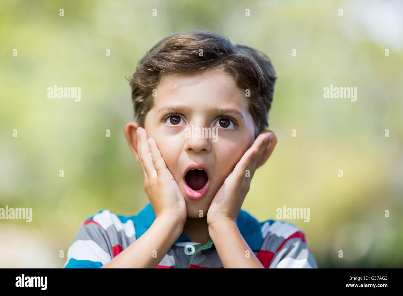 Young boy making surprise expression while pulling out funny faces ...