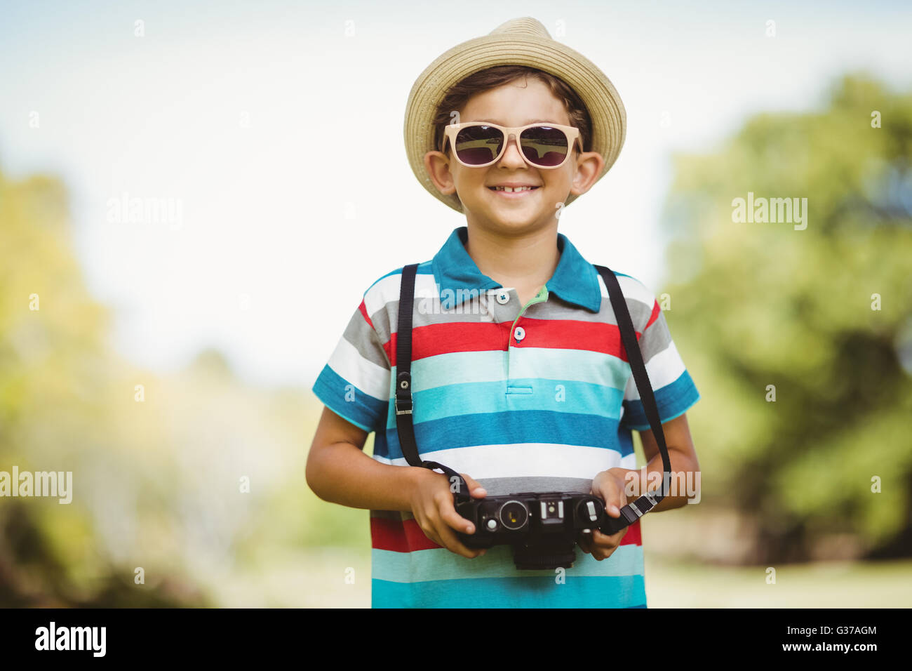 Young boy in sunglasses holding a camera Stock Photo - Alamy