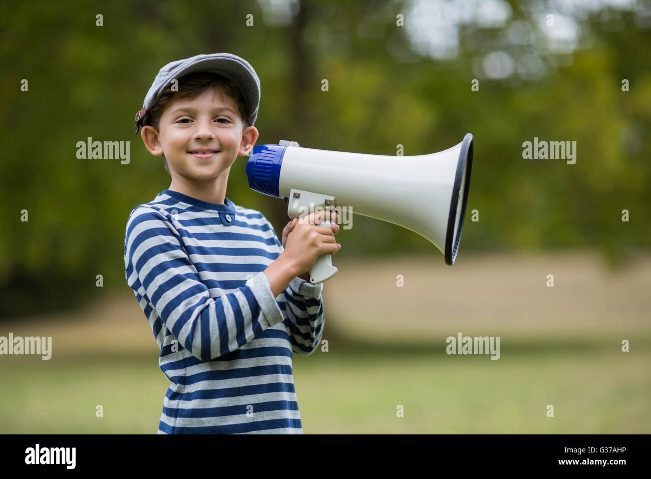 Smiling boy holding megaphone Stock Photo - Alamy