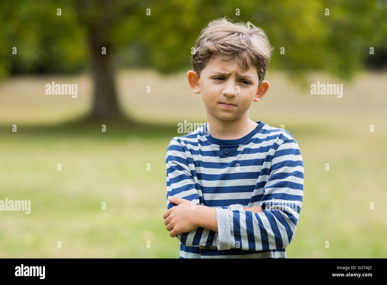Portrait of upset boy standing with arms crossed Stock Photo - Alamy