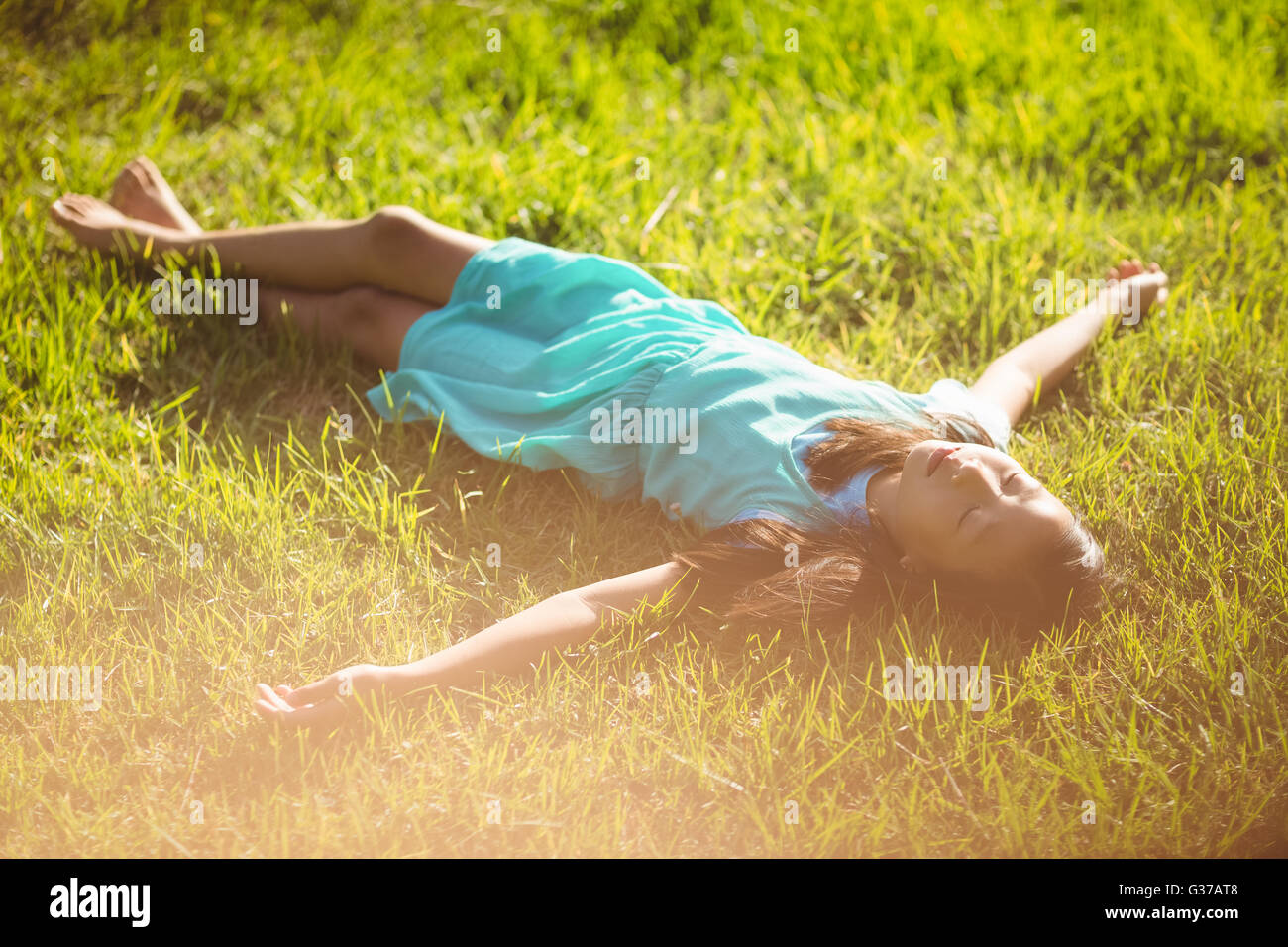 Cute young girl lying on grass in park Stock Photo - Alamy
