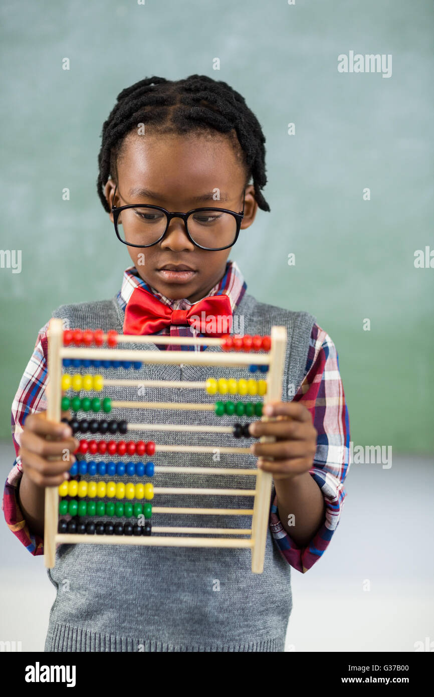 Schoolboy using a maths abacus in classroom Stock Photo - Alamy