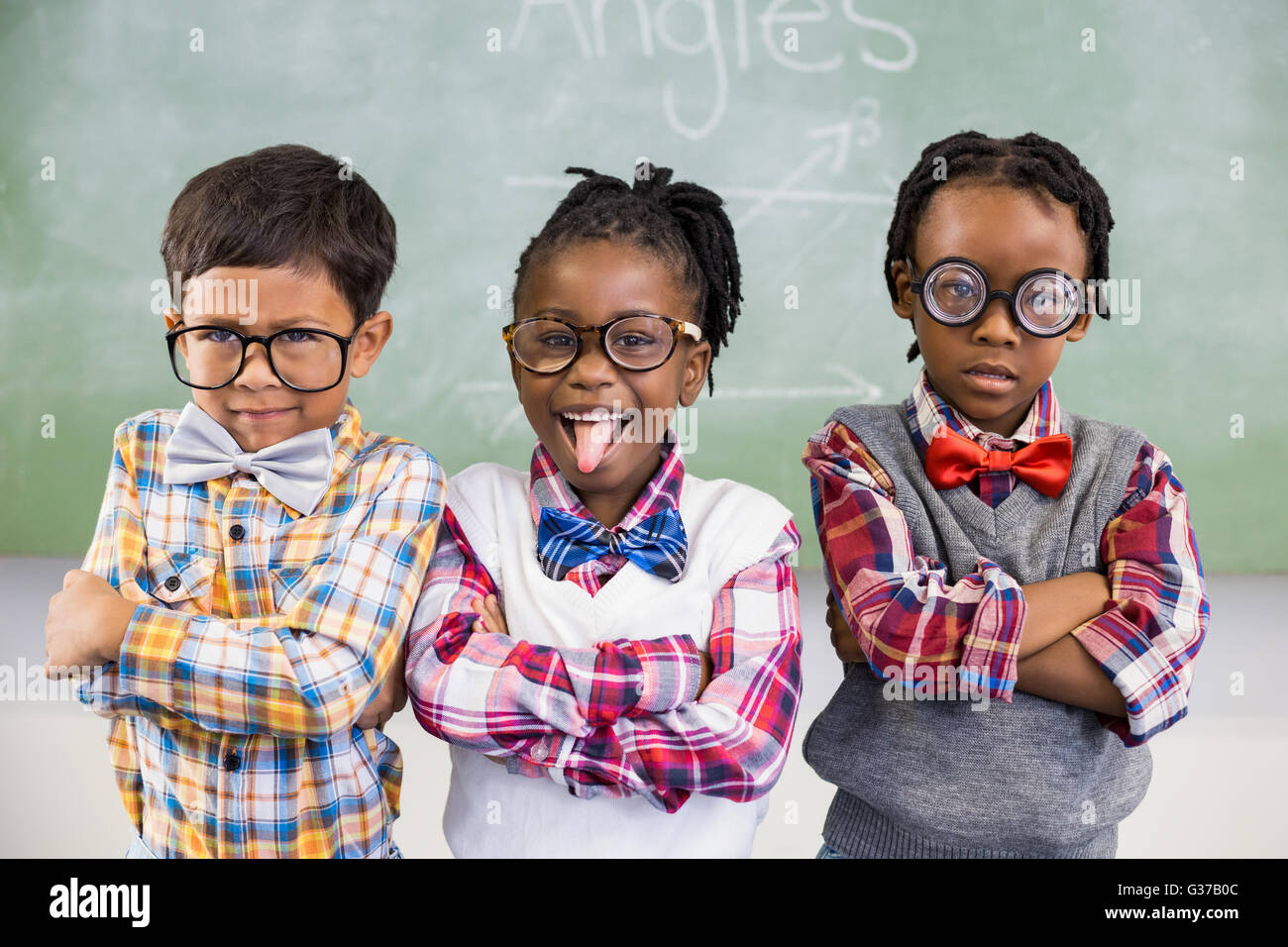 Portrait of three school kids standing against chalkboard Stock Photo ...