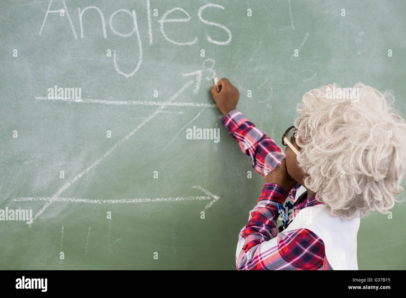 Schoolboy doing mathematics on chalkboard in classroom Stock Photo - Alamy