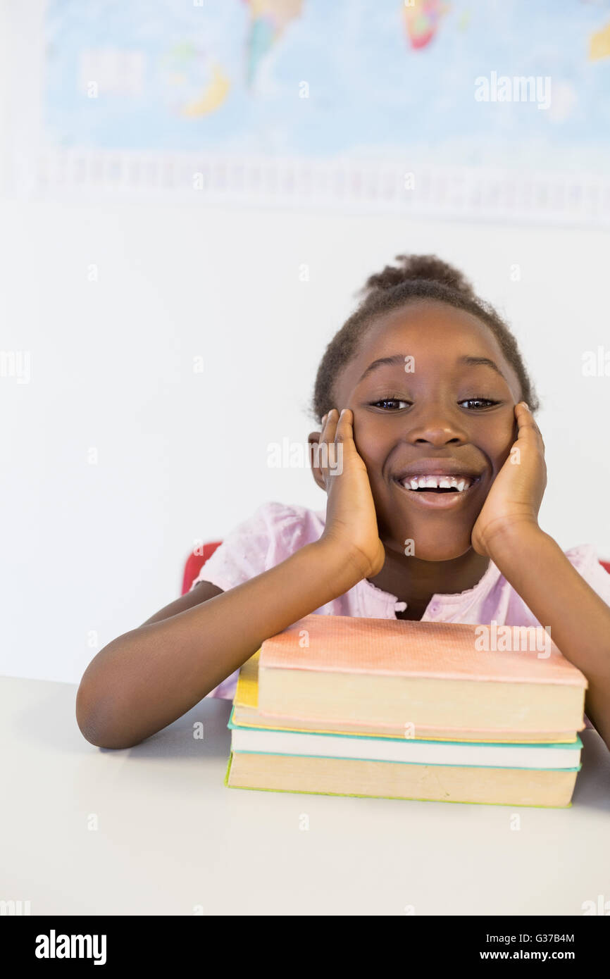 Portrait of smiling girl with books in classroom Stock Photo - Alamy