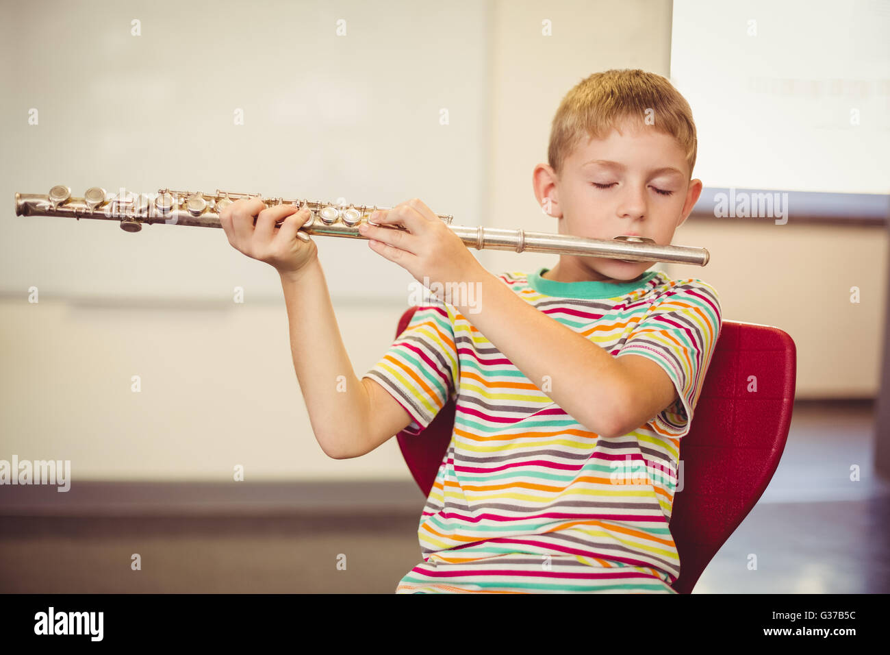 Schoolboy playing flute in classroom Stock Photo - Alamy