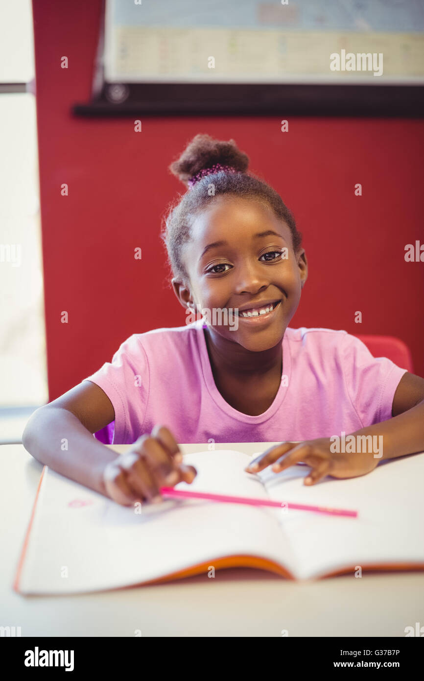 Portrait of schoolgirl doing homework in classroom Stock Photo - Alamy
