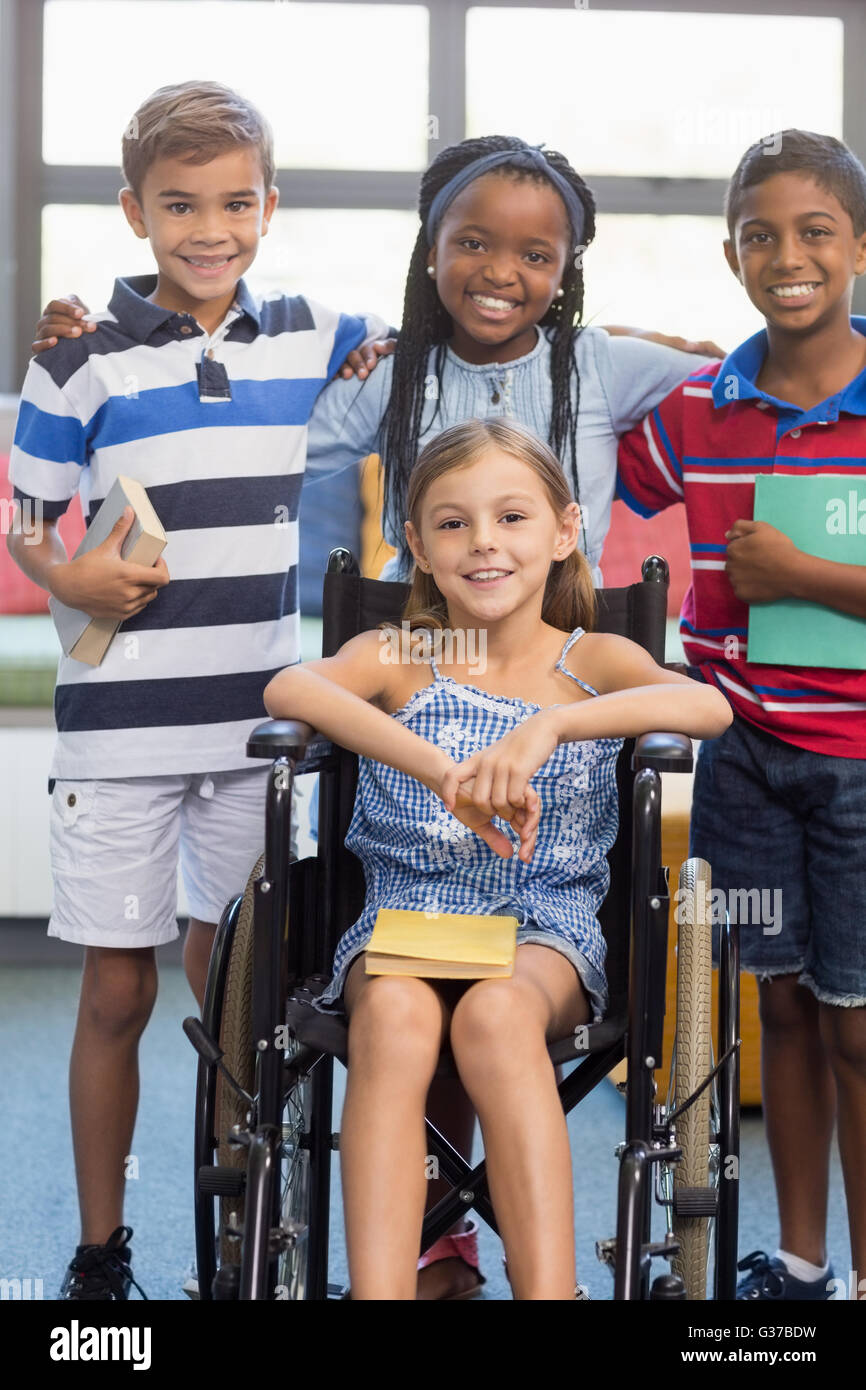 Smiling school kids standing with arm around in library Stock Photo - Alamy