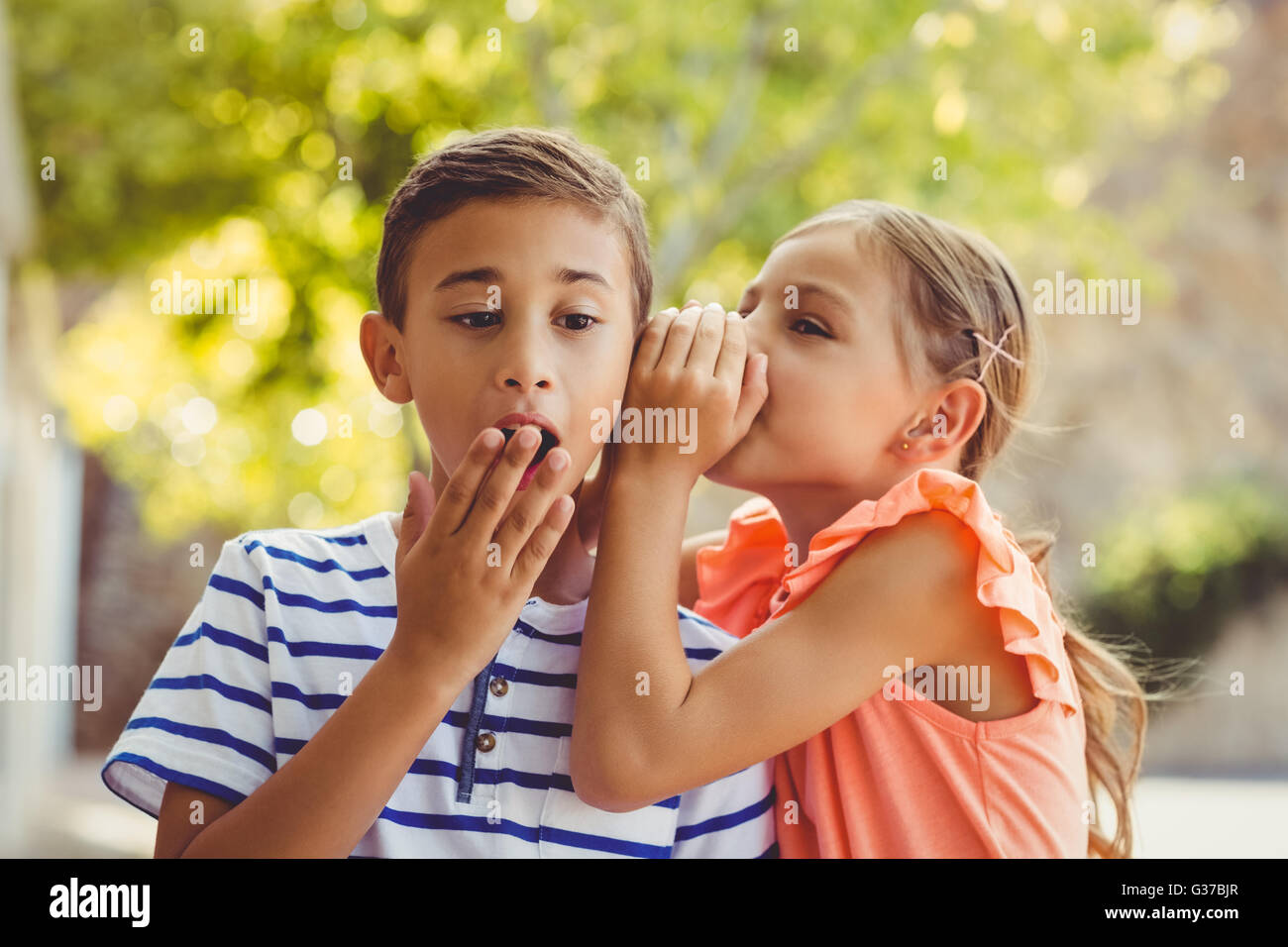 Girl whispering in boy's ear hi-res stock photography and images - Alamy