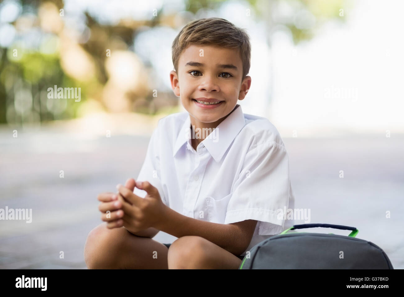 Happy school boy sitting in campus Stock Photo - Alamy
