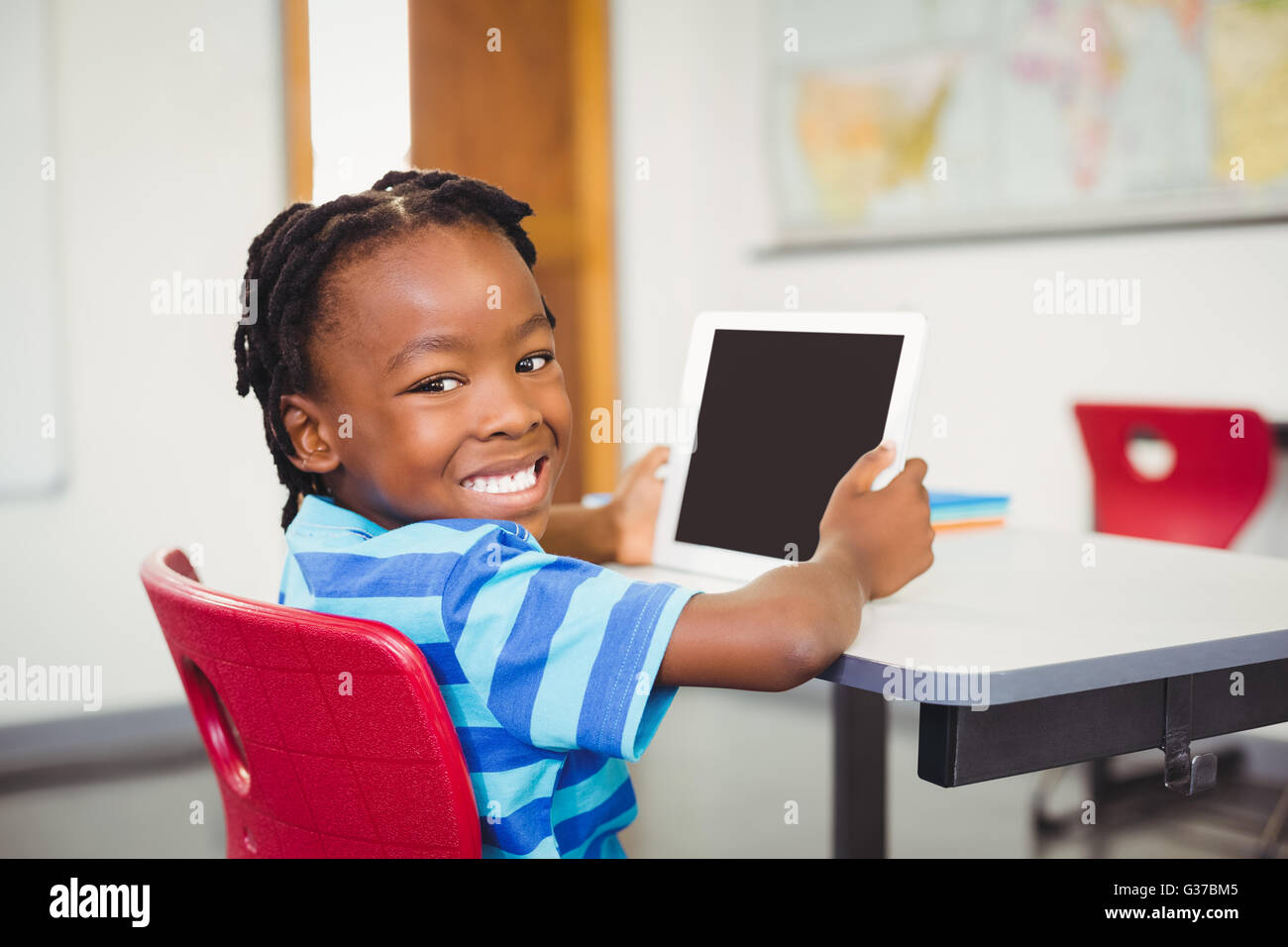 Portrait of schoolboy holding digital tablet in classroom Stock Photo ...