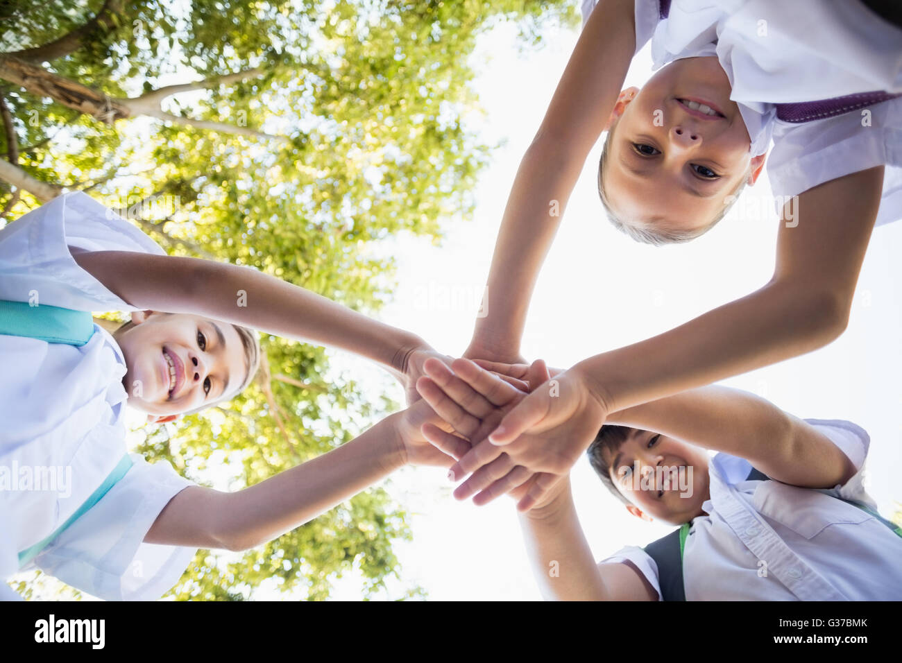 School kids stacking hands in campus Stock Photo - Alamy