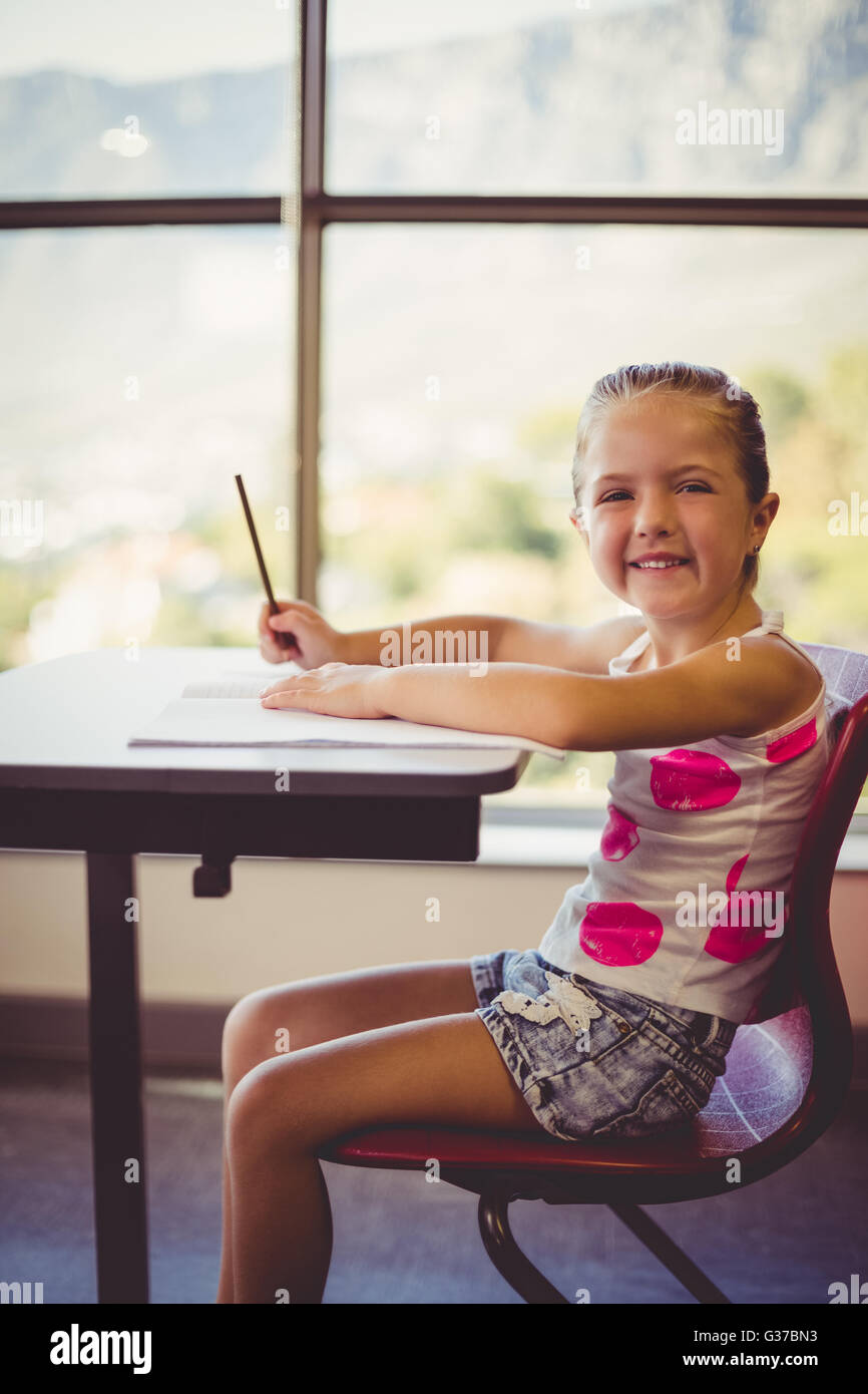 Girl doing homework in classroom Stock Photo - Alamy