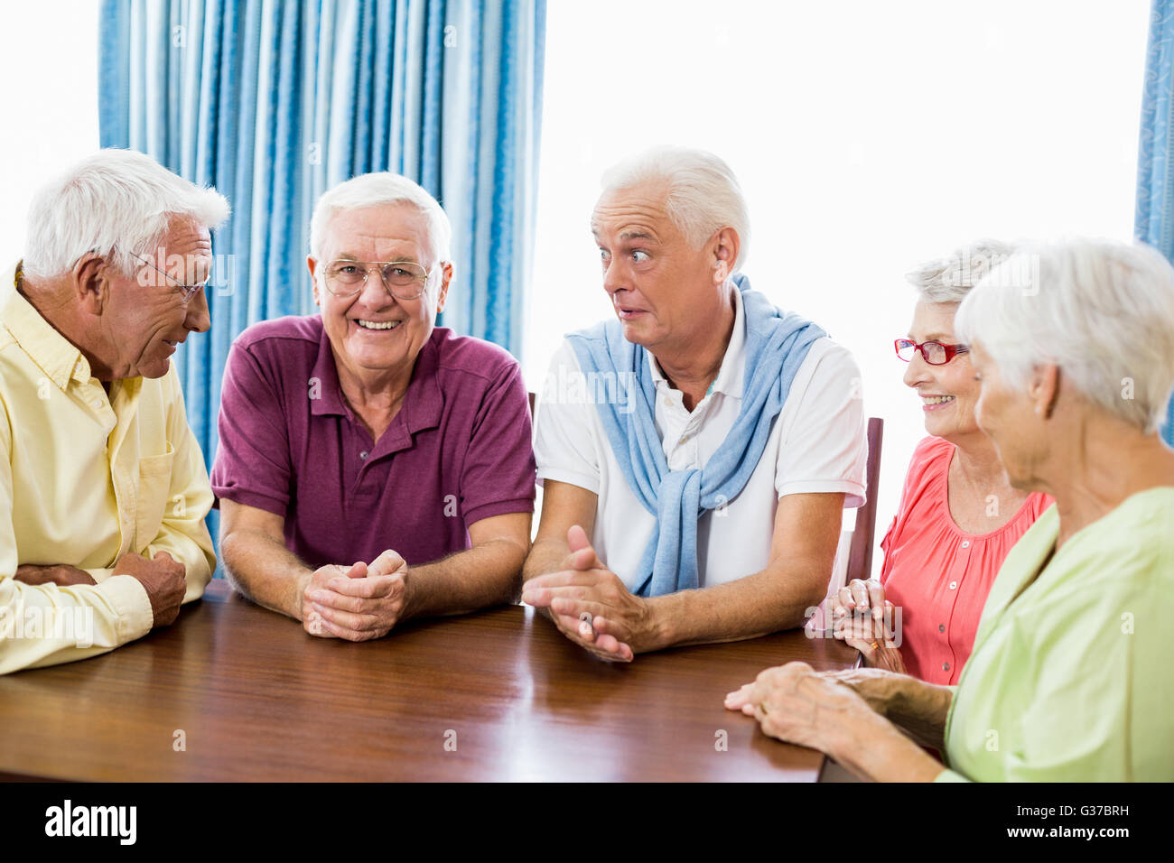 Seniors talking at table Stock Photo - Alamy