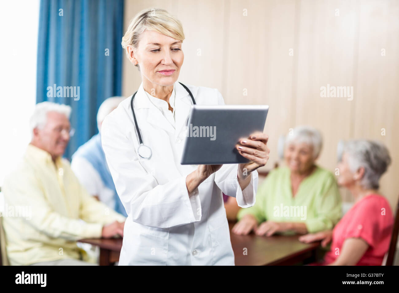 Nurse using a tablet standing Stock Photo - Alamy