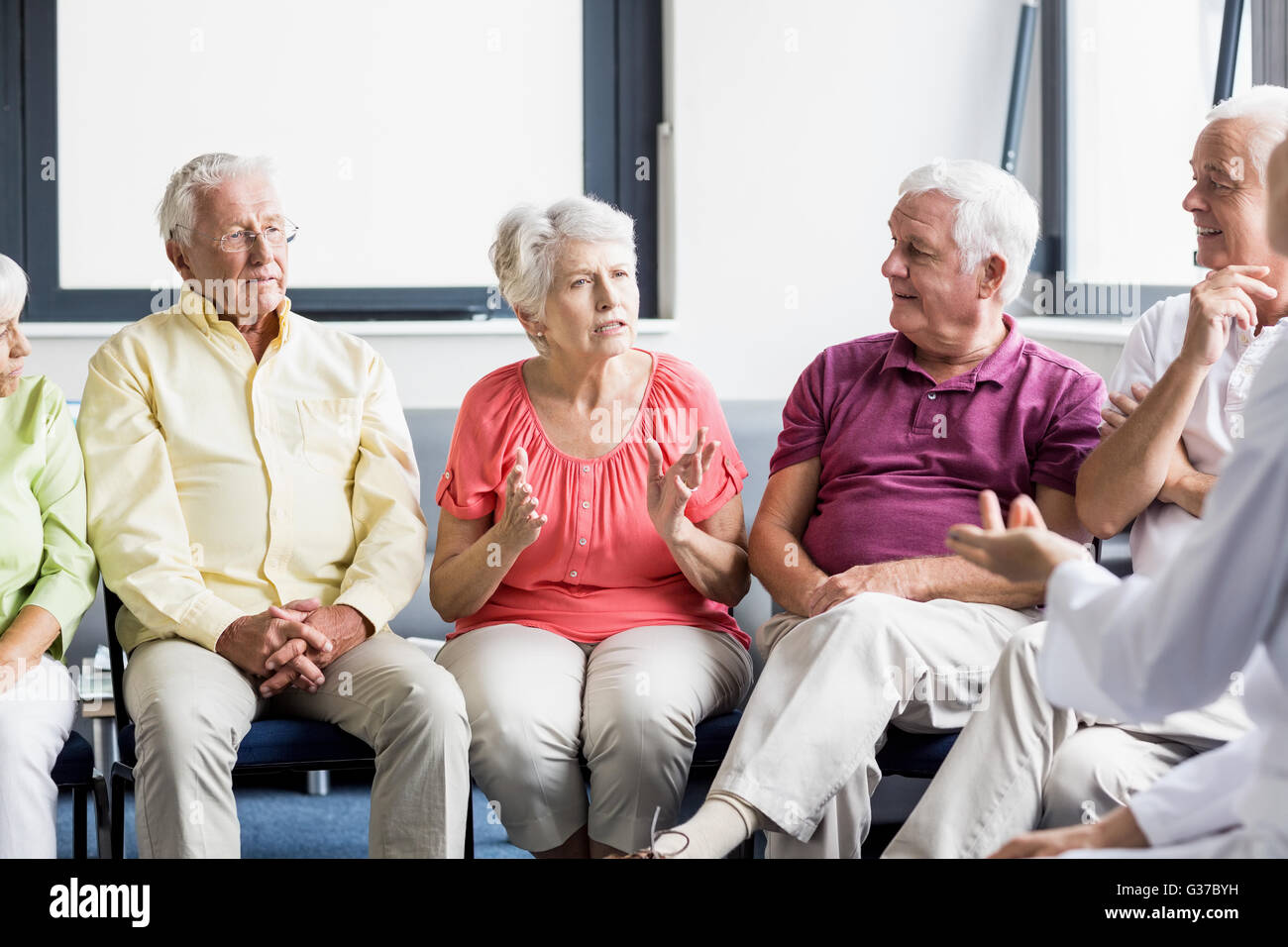 Seniors and nurse talking to each other Stock Photo - Alamy