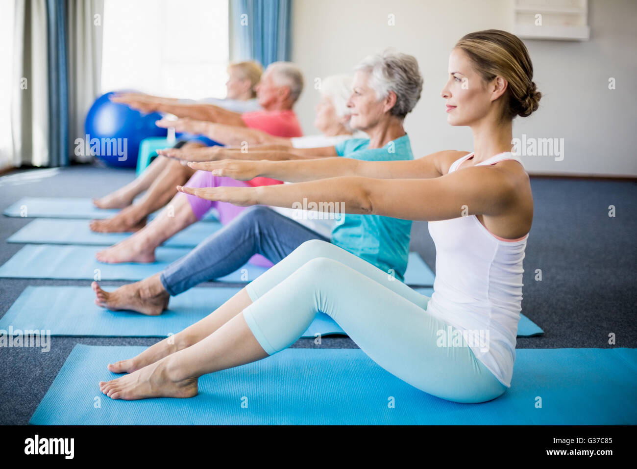 Instructor performing yoga with seniors Stock Photo - Alamy