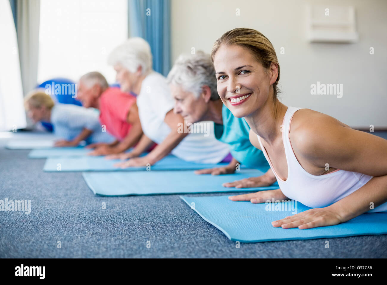 Instructor performing yoga with seniors Stock Photo - Alamy