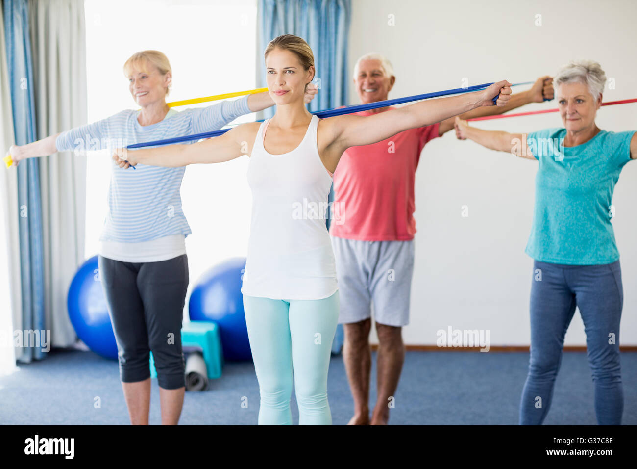 Instructor and seniors exercising with stretching bands Stock Photo - Alamy
