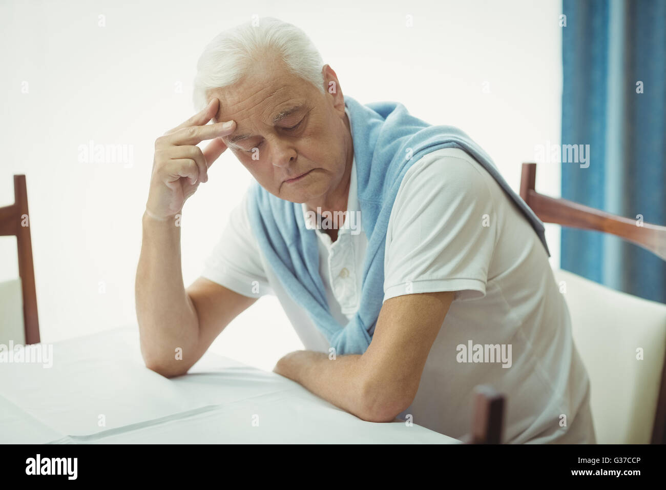 Sad senior man sitting at table Stock Photo - Alamy