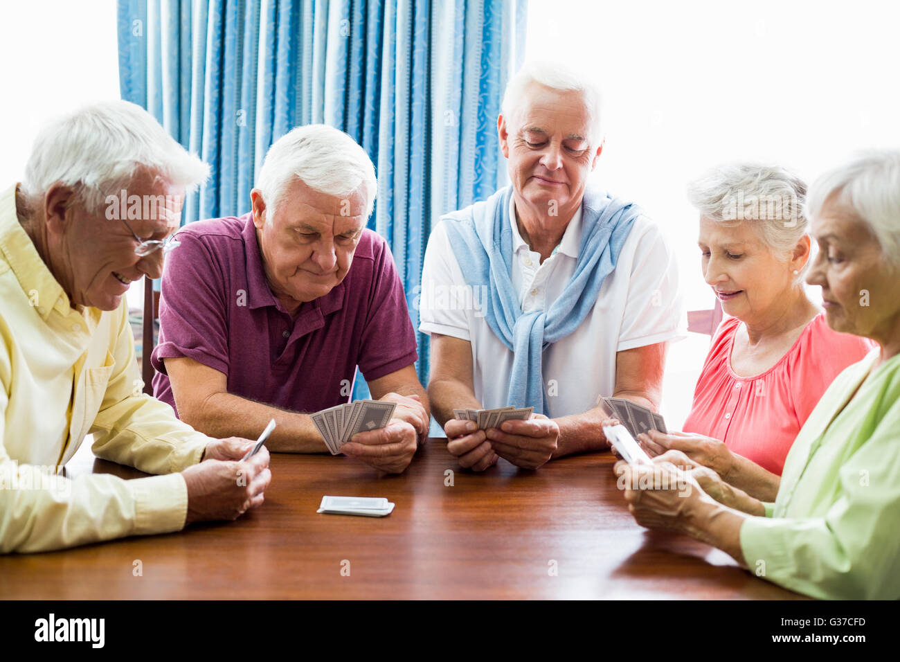 Seniors playing cards together Stock Photo - Alamy