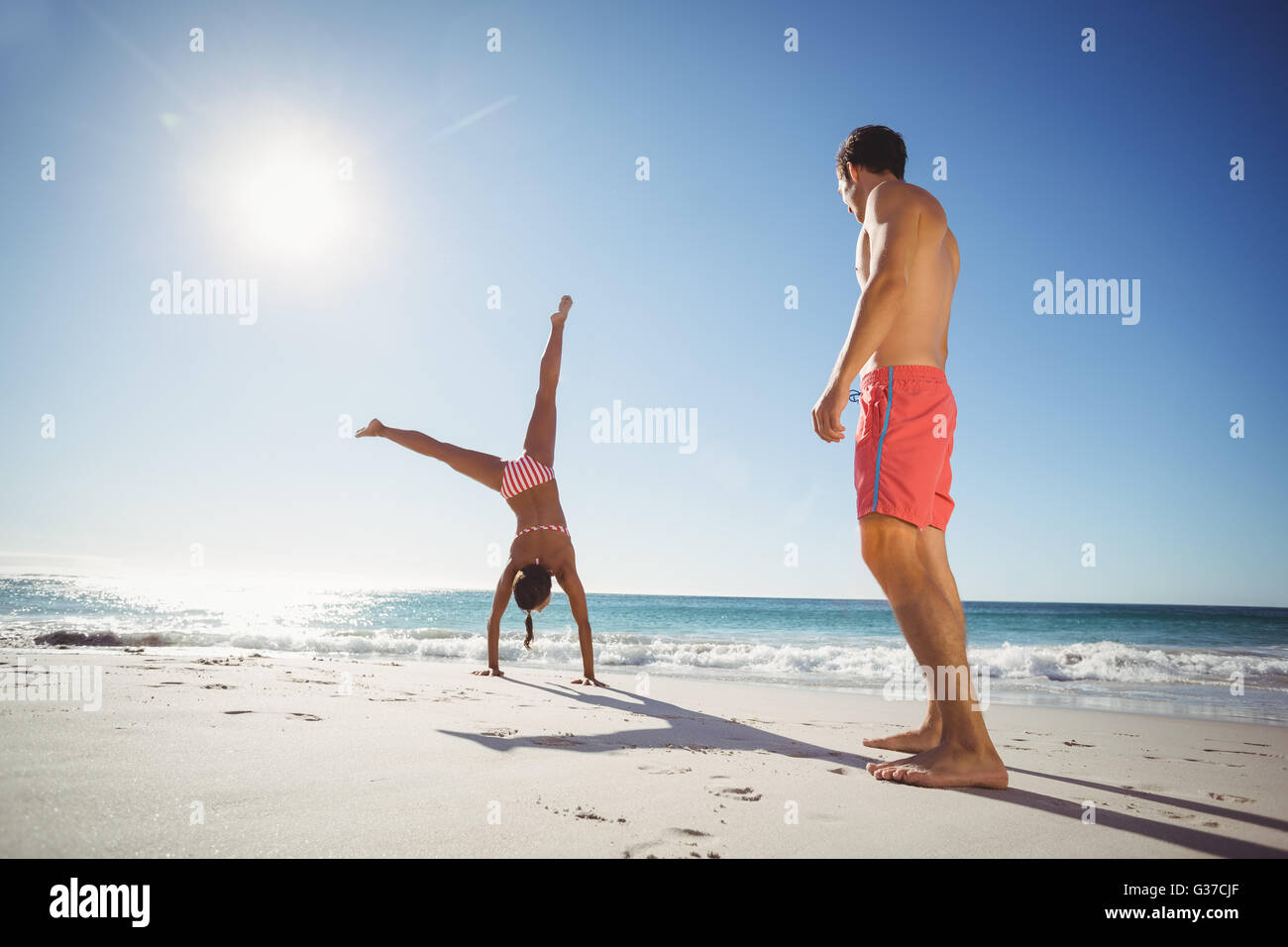 Woman performing somersault on beach Stock Photo - Alamy