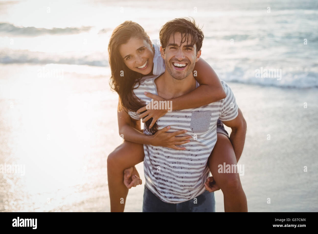 Man giving woman piggyback ride Stock Photo - Alamy