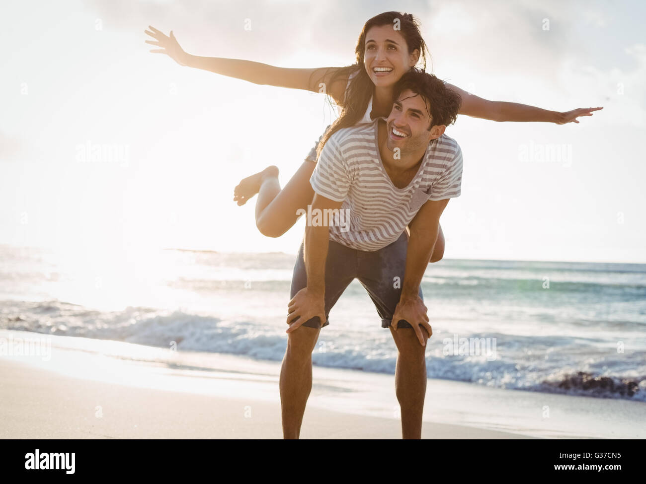 Man giving woman piggyback ride Stock Photo - Alamy