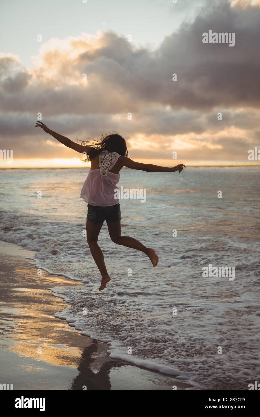 Woman jumping on the beach Stock Photo - Alamy