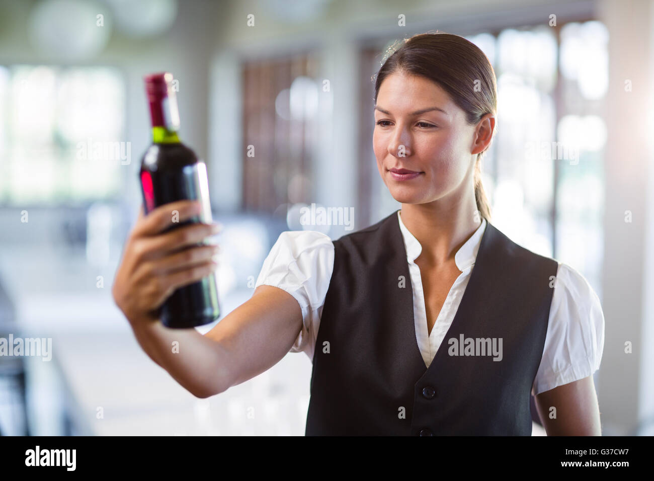 Waitress holding a wine bottle Stock Photo - Alamy