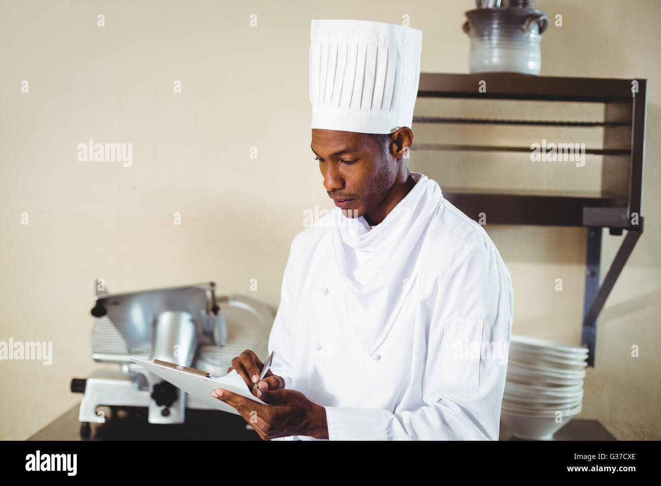 Chef making notes on a clipboard Stock Photo - Alamy