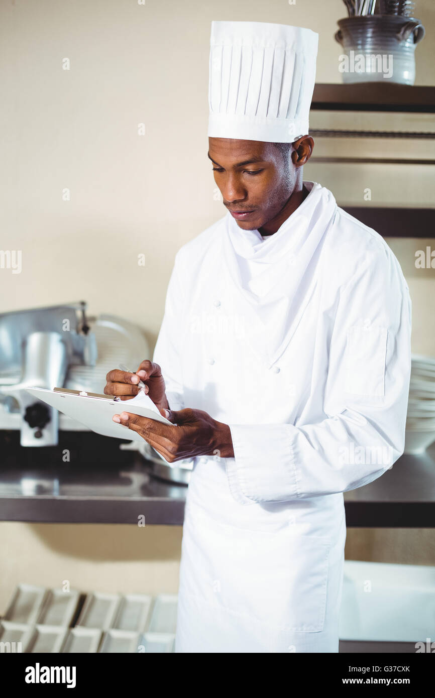 Chef writing notes on a clipboard Stock Photo - Alamy