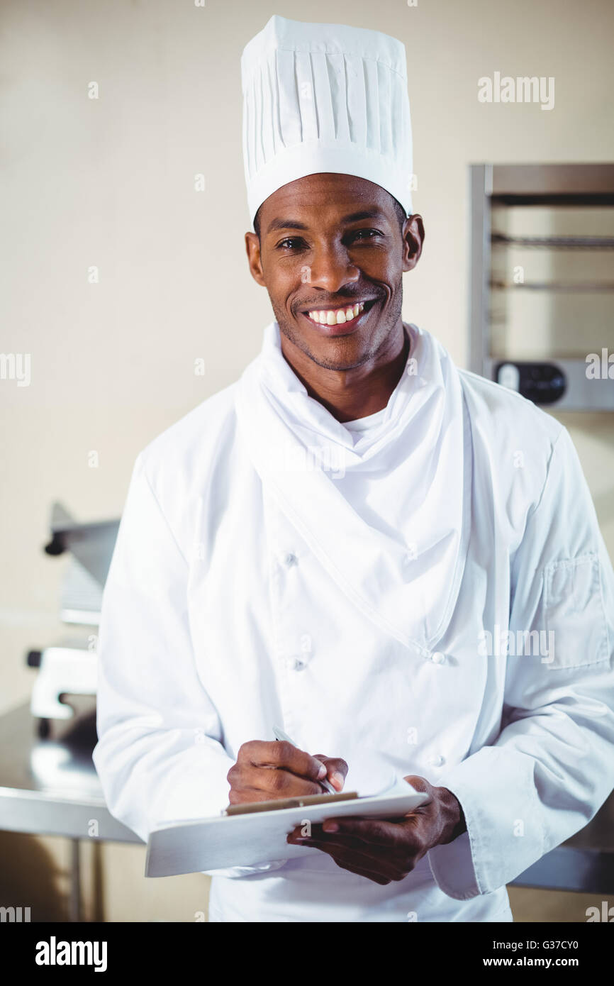Portrait of smiling chef making notes on a clipboard Stock Photo - Alamy