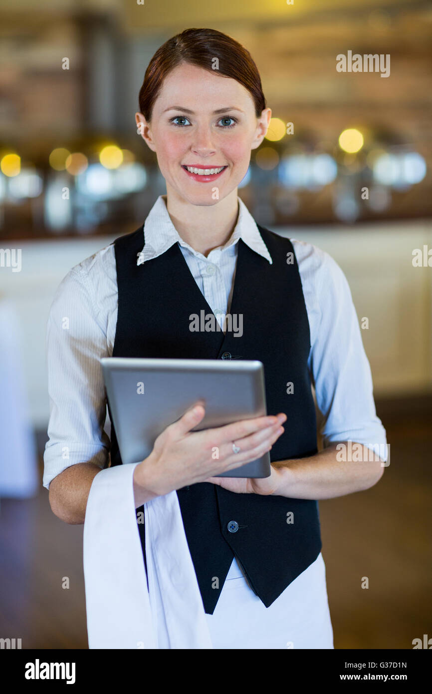 Portrait of smiling waitress holding digital tablet Stock Photo - Alamy