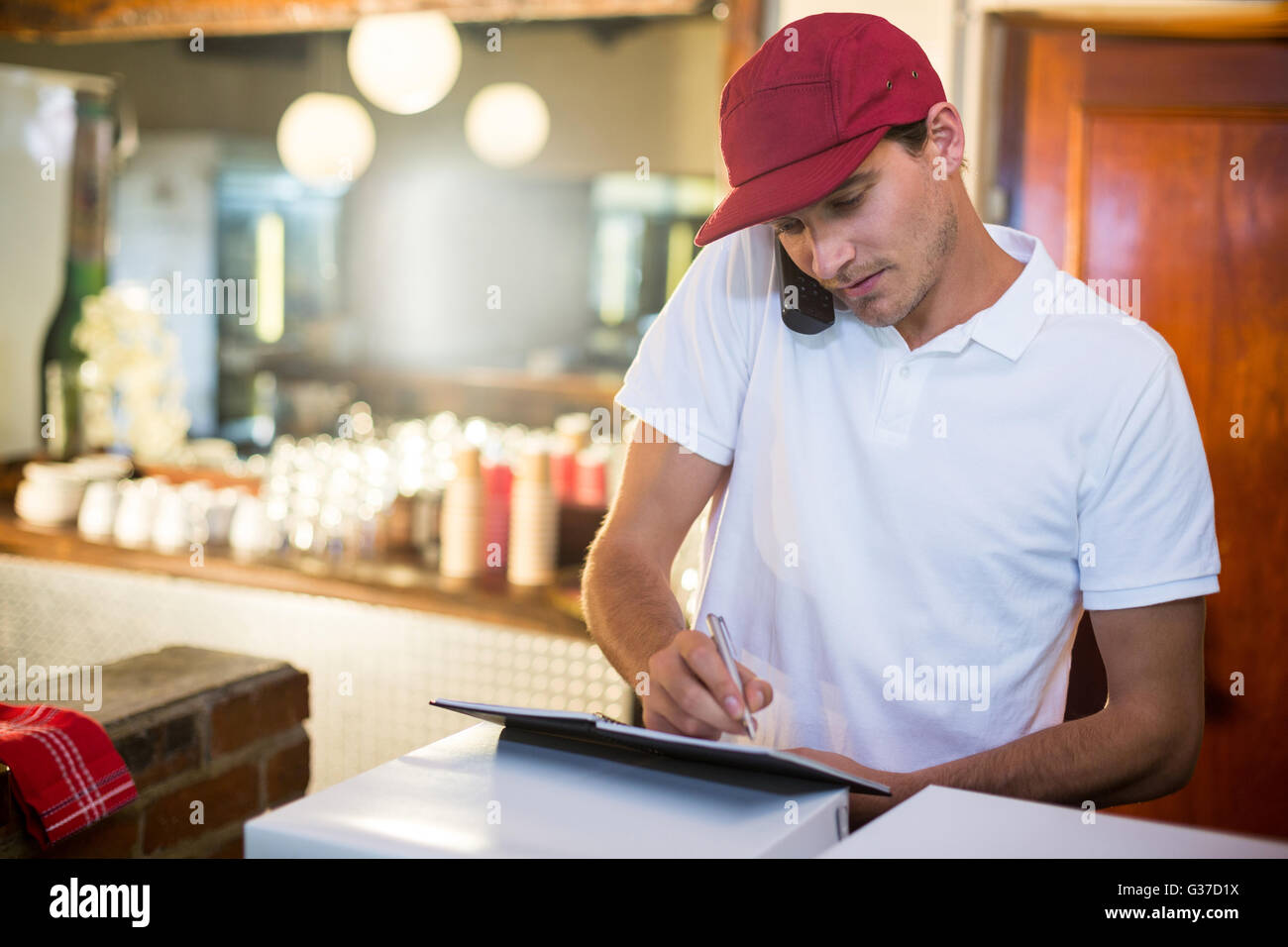 Pizza delivery man taking an order over the phone Stock Photo - Alamy