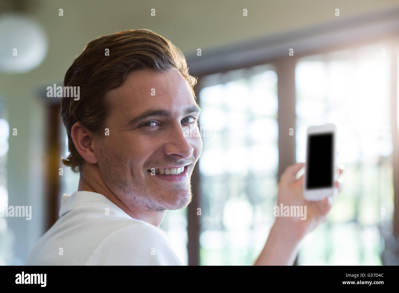 Smiling man holding mobile phone Stock Photo - Alamy