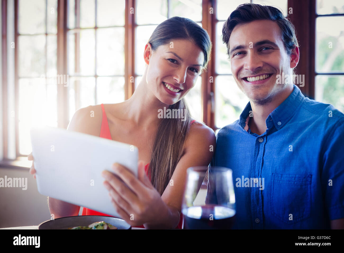 Portrait of happy couple using a digital tablet during lunch Stock Photo - Alamy
