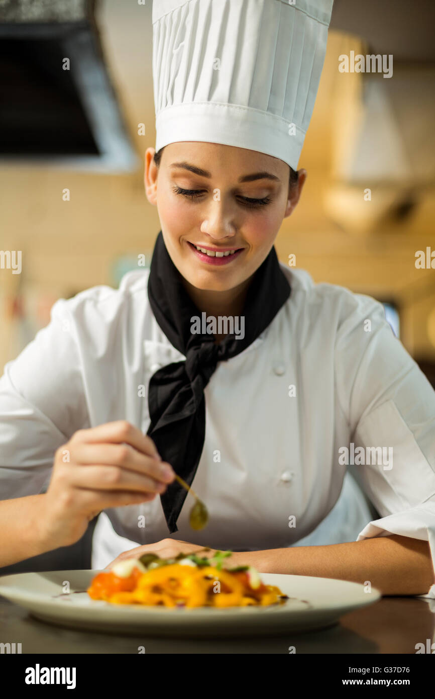 Happy head chef garnishing pasta dish with olive Stock Photo - Alamy