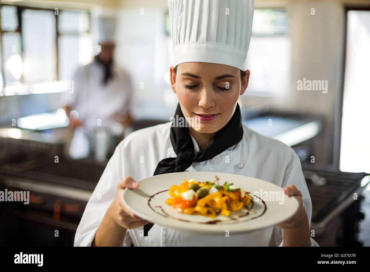 Head chef with eyes closed smelling food Stock Photo - Alamy