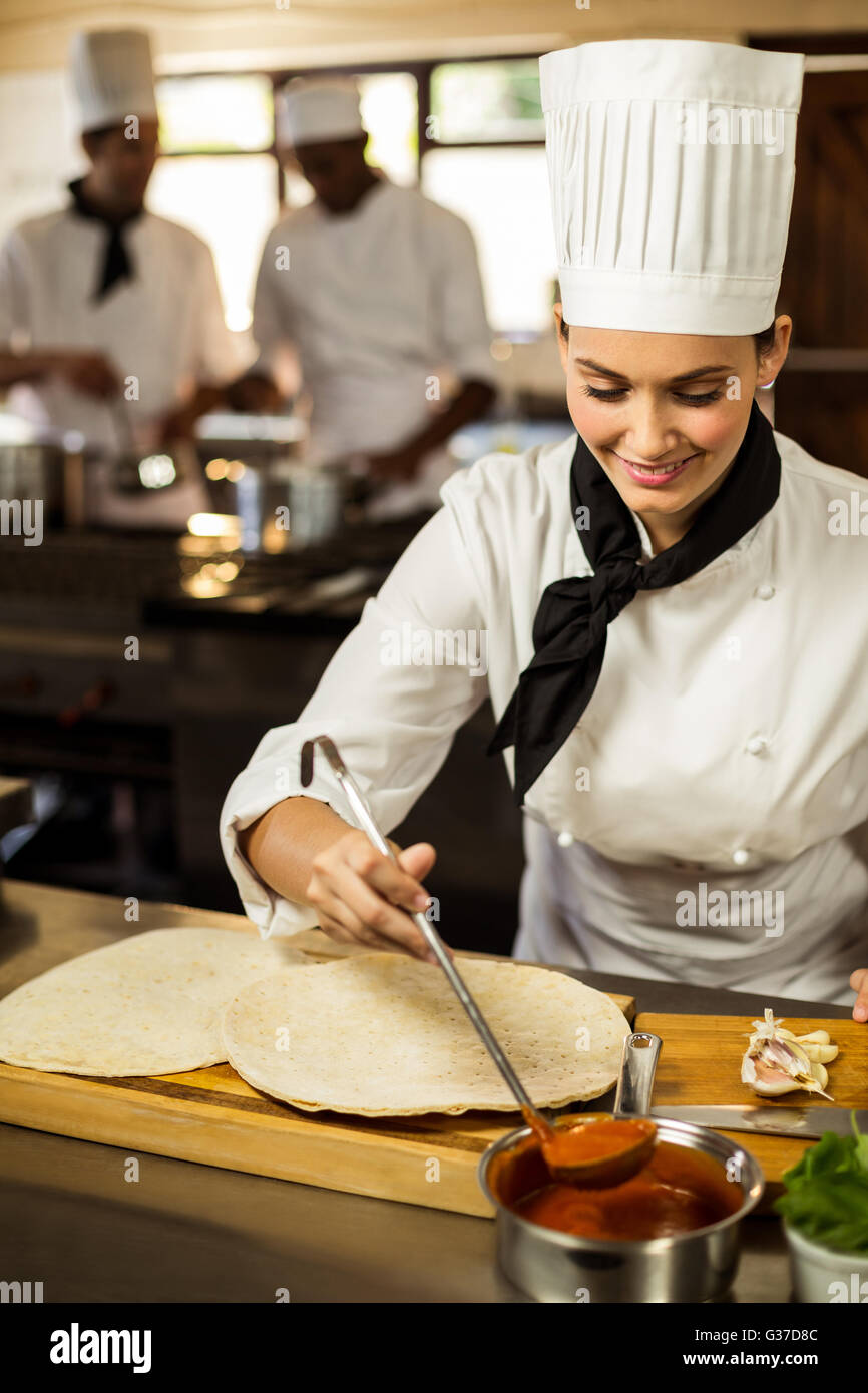 Head chef spreading sauce on a pizza Stock Photo - Alamy