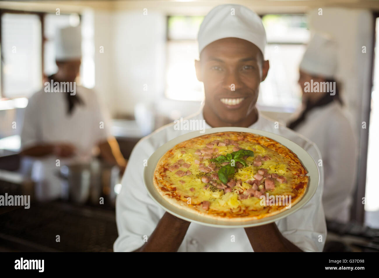 Portrait of smiling chef showing pizza Stock Photo - Alamy
