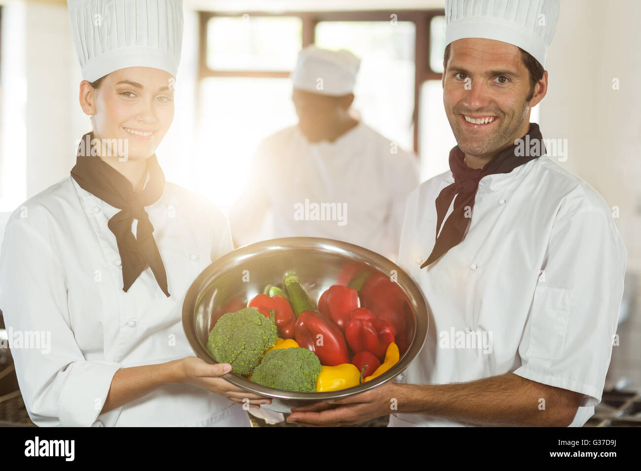 Portrait of two smiling chef holding a bowl of vegetable Stock Photo ...
