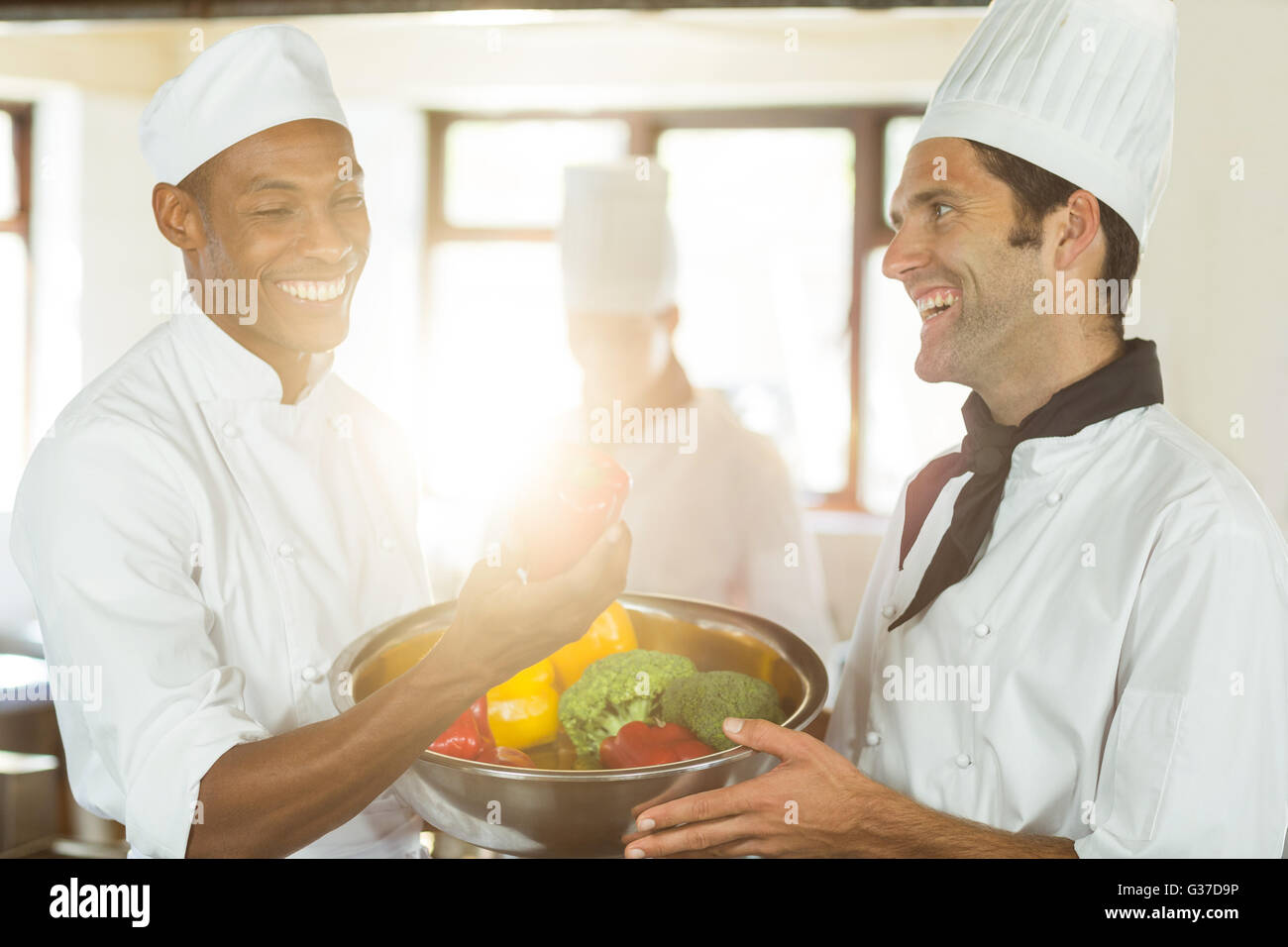 Two smiling chef holding a bowl of vegetable Stock Photo - Alamy
