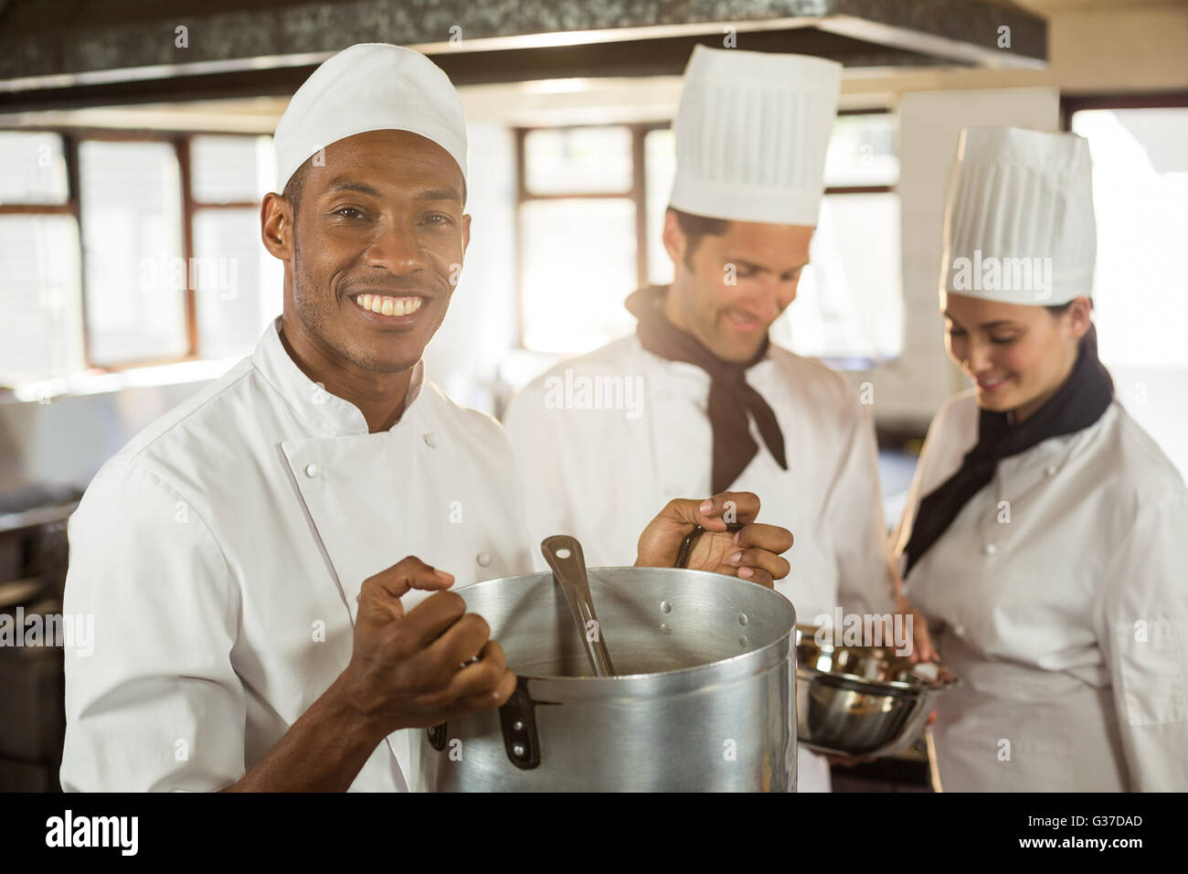 Portrait of smiling chef holding a cooking pot Stock Photo - Alamy