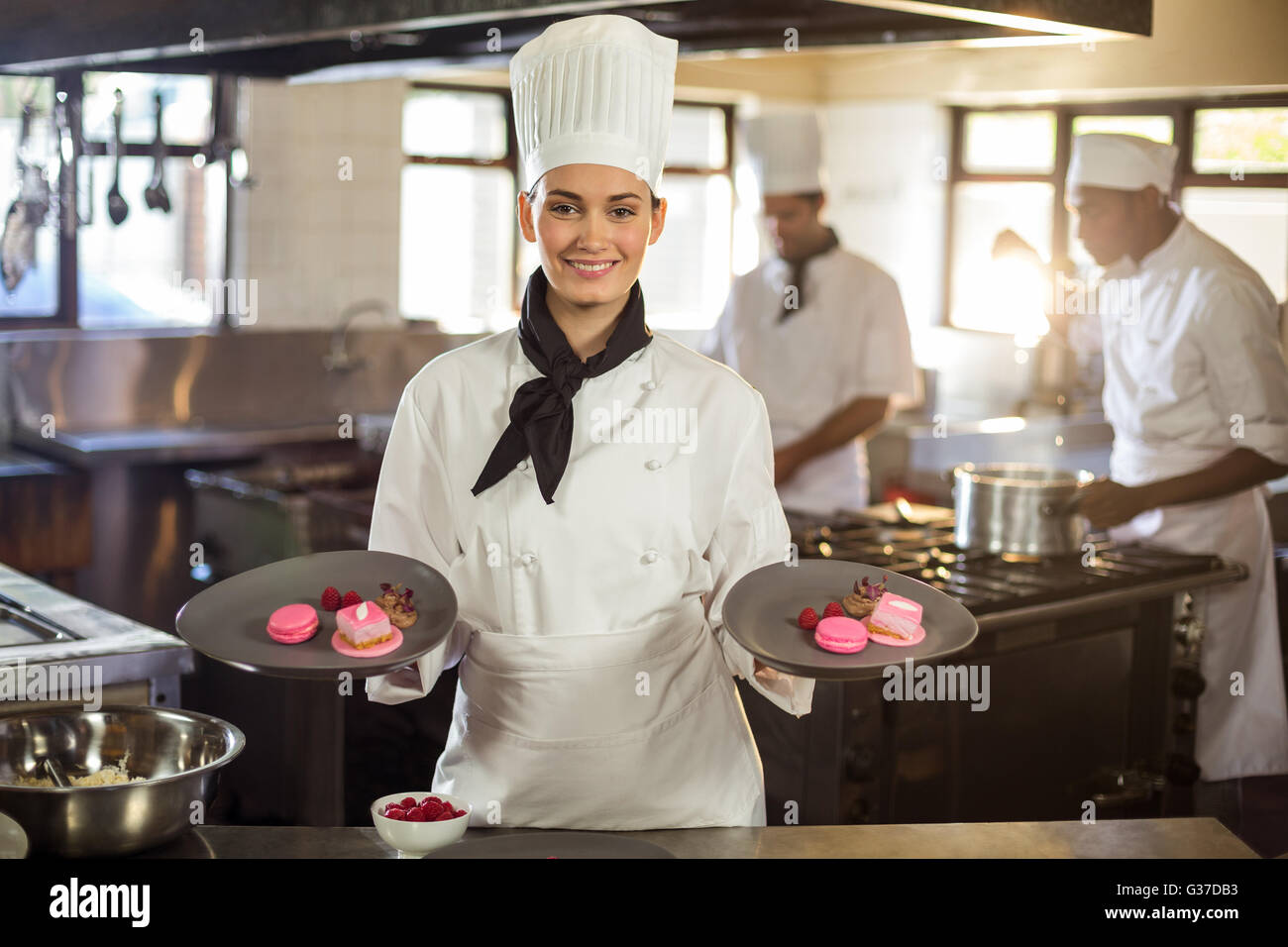 Portrait of smiling female chef presenting dessert plates Stock Photo ...