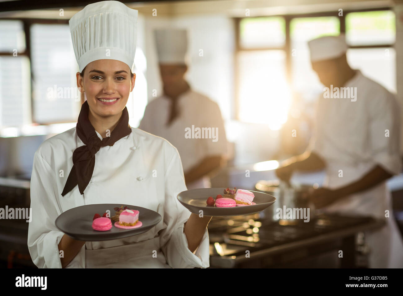 Portrait of smiling female chef presenting dessert plates Stock Photo ...